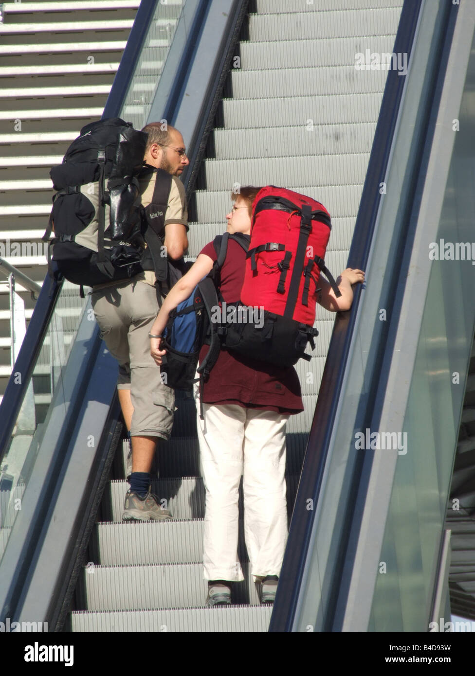 two travellers with backpacks on escalators in city town Stock Photo ...
