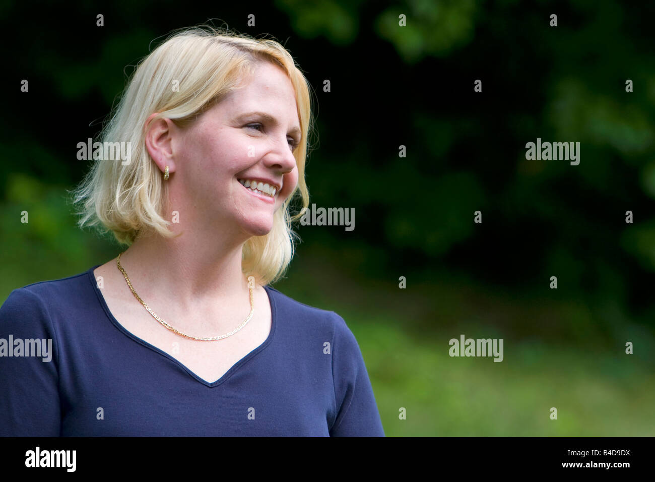 Pretty woman outside against green background Stock Photo - Alamy