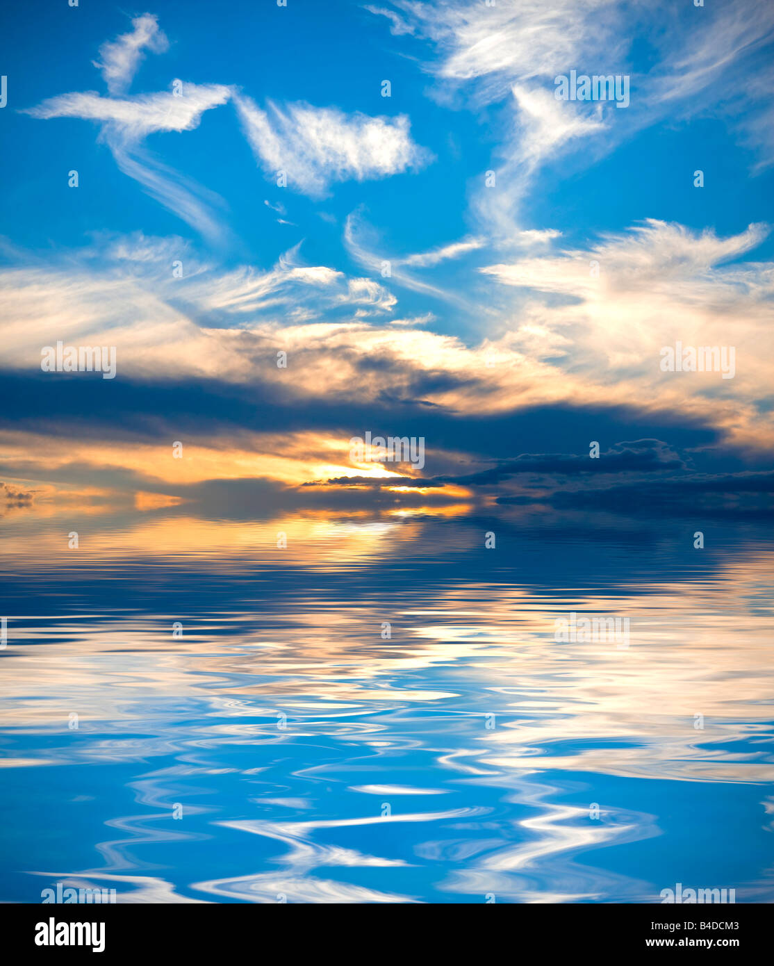 Beautiful sunset with vivid blue sky and light clouds reflected over ...