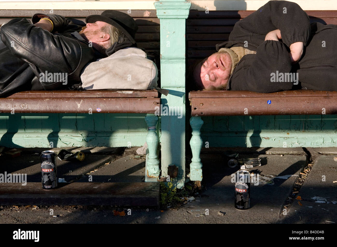 Two homeless men sleeping on a bench Stock Photo - Alamy