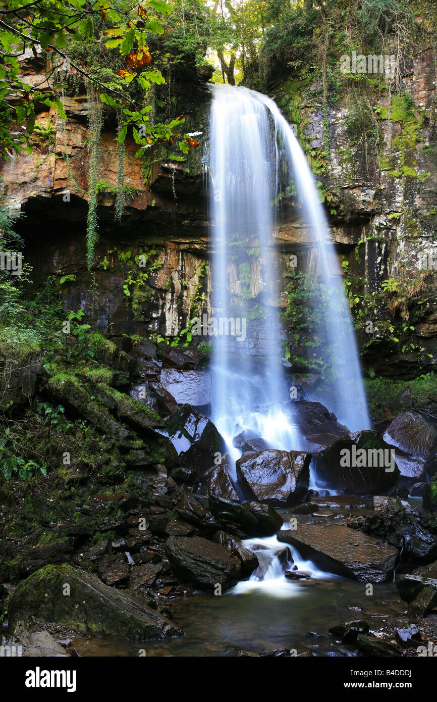 Closeup single waterfall flows falls onto over river bed rocks ...