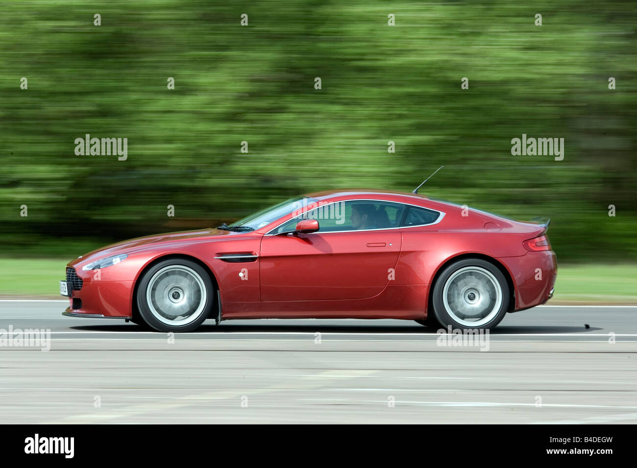 Aston Martin V8 Vantage, model year 2007-, ruby colored, driving, side ...