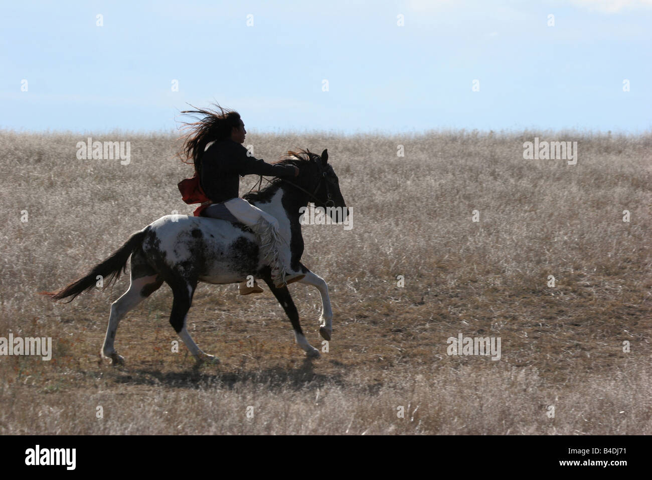 A Native American Lakota Sioux Indian riding horseback on the prairie ...