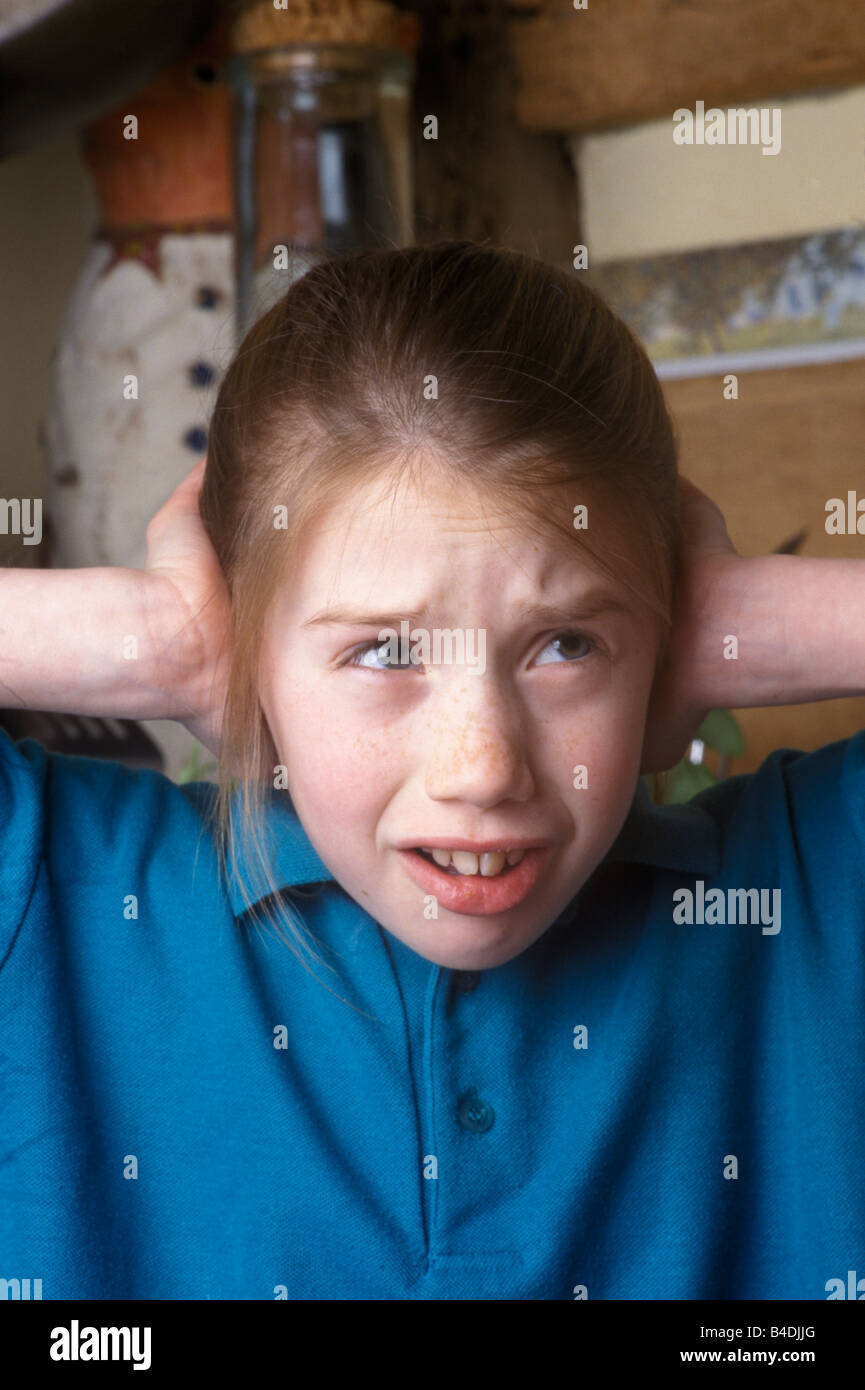 little girl with her hands over her ears Stock Photo - Alamy