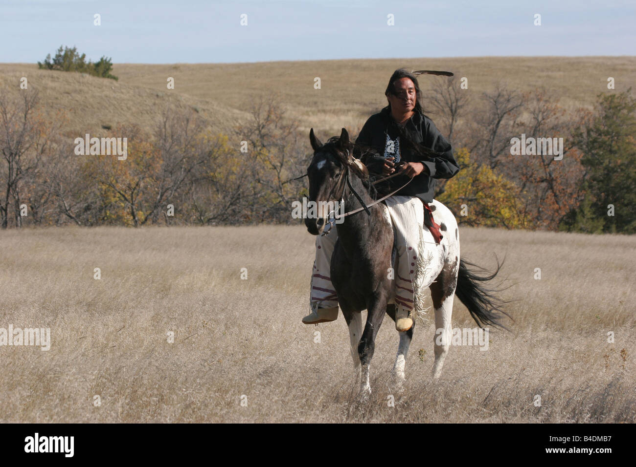 A Native American Lakota Sioux Indian riding horseback on the prairie ...