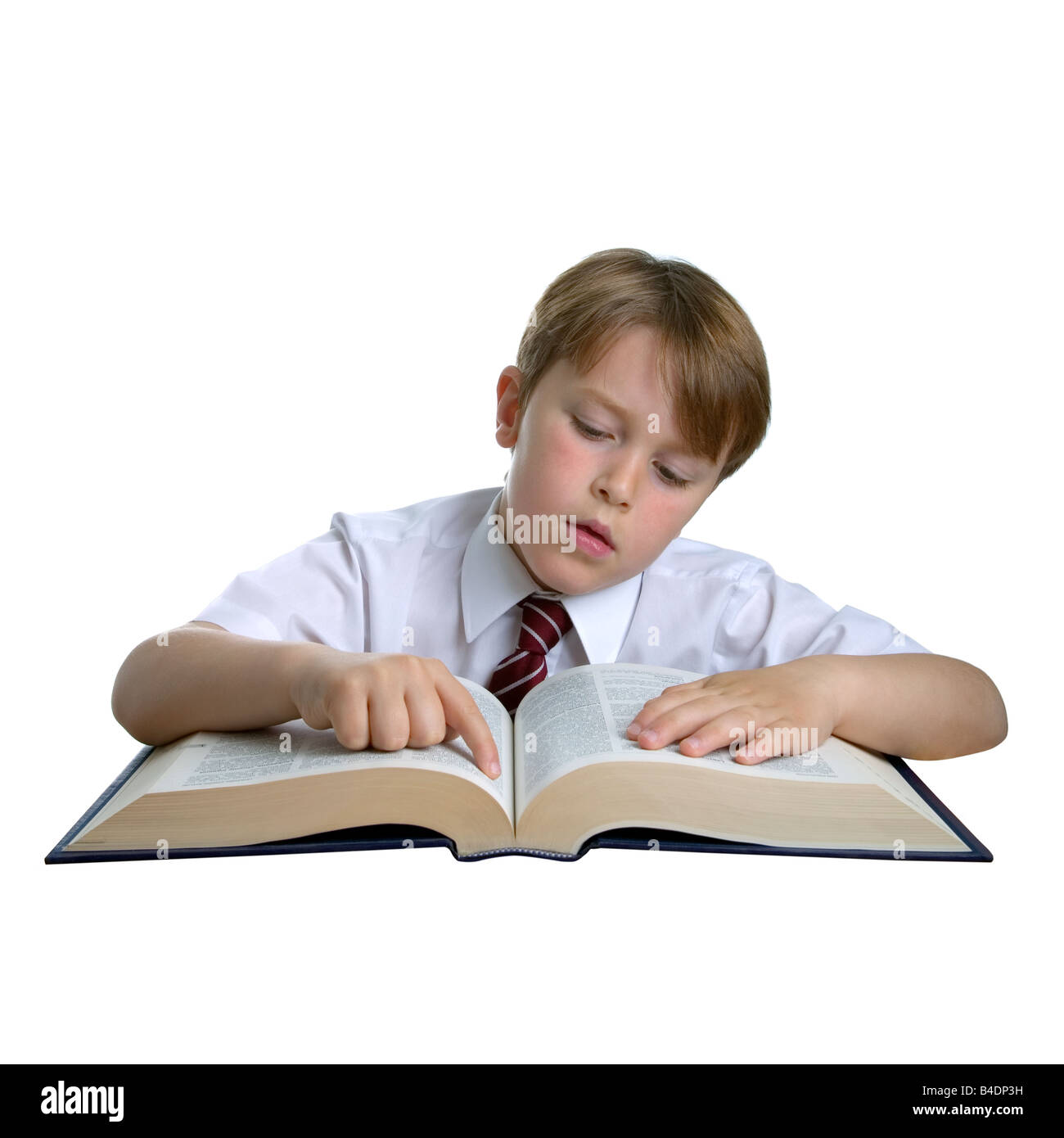 Cut out of a schoolboy reading a reference book whilst doing his school ...