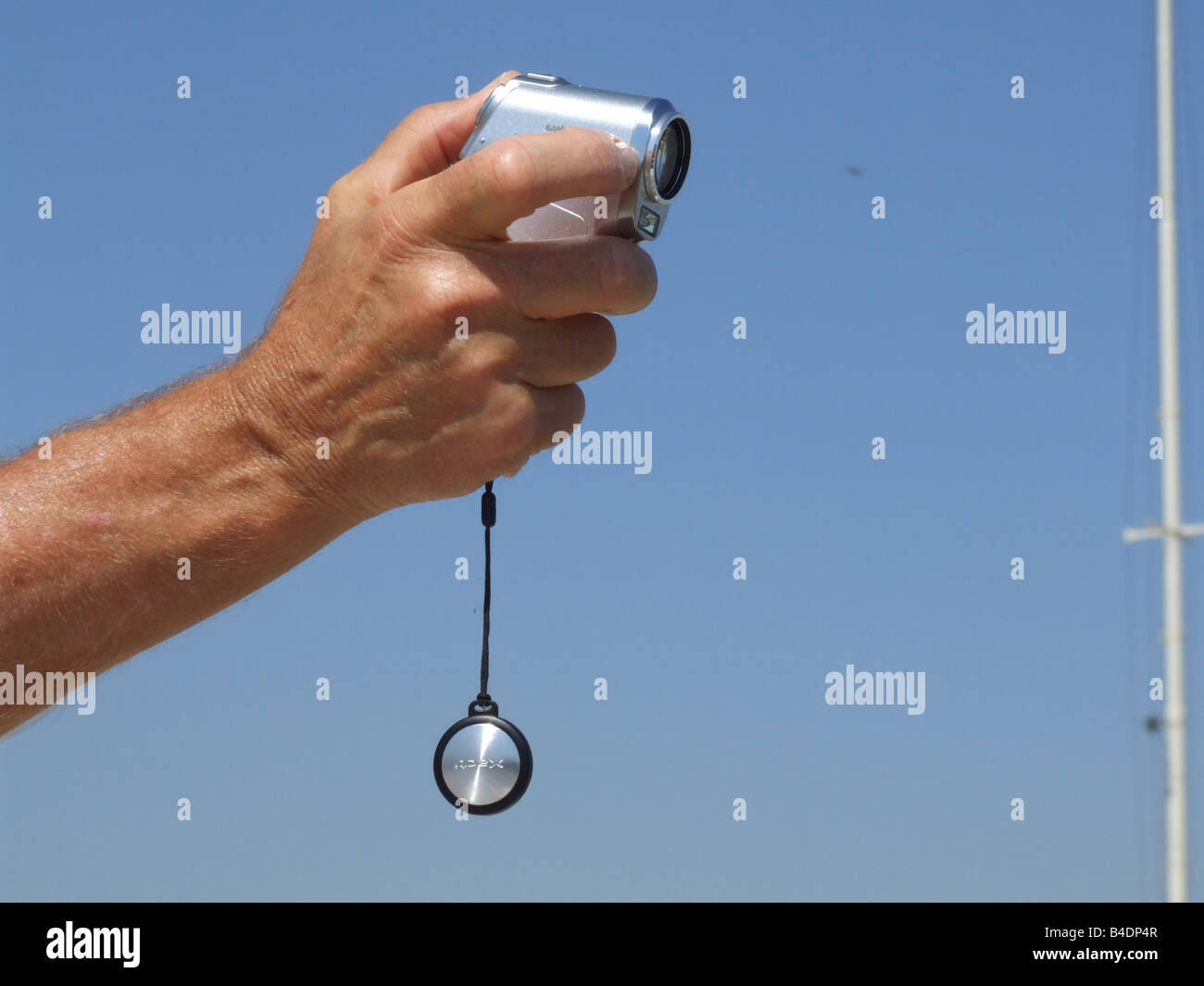 person using small video camera outside in sun Stock Photo - Alamy