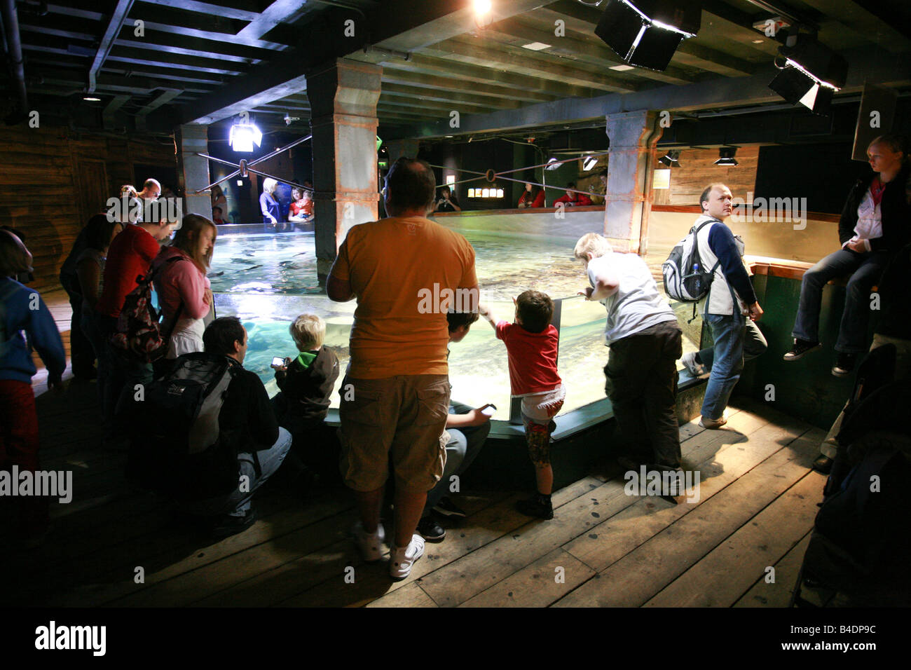 Tourists crowd around a glass fish tank at the London Aquarium a major ...