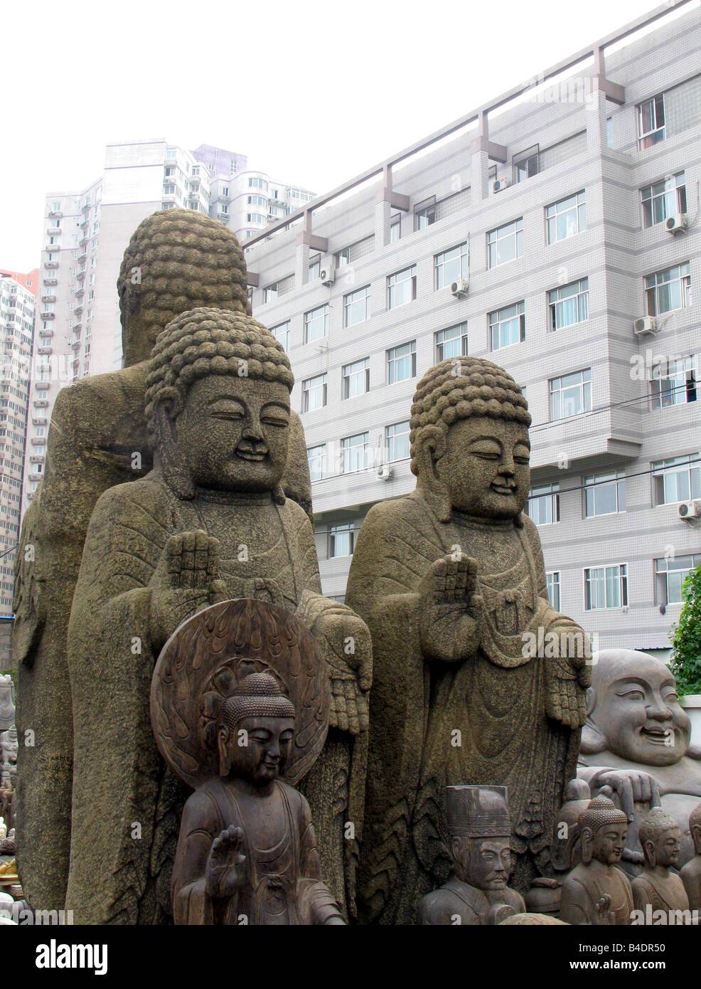Buddha statues standing in front of modern flats in Beijing, China ...