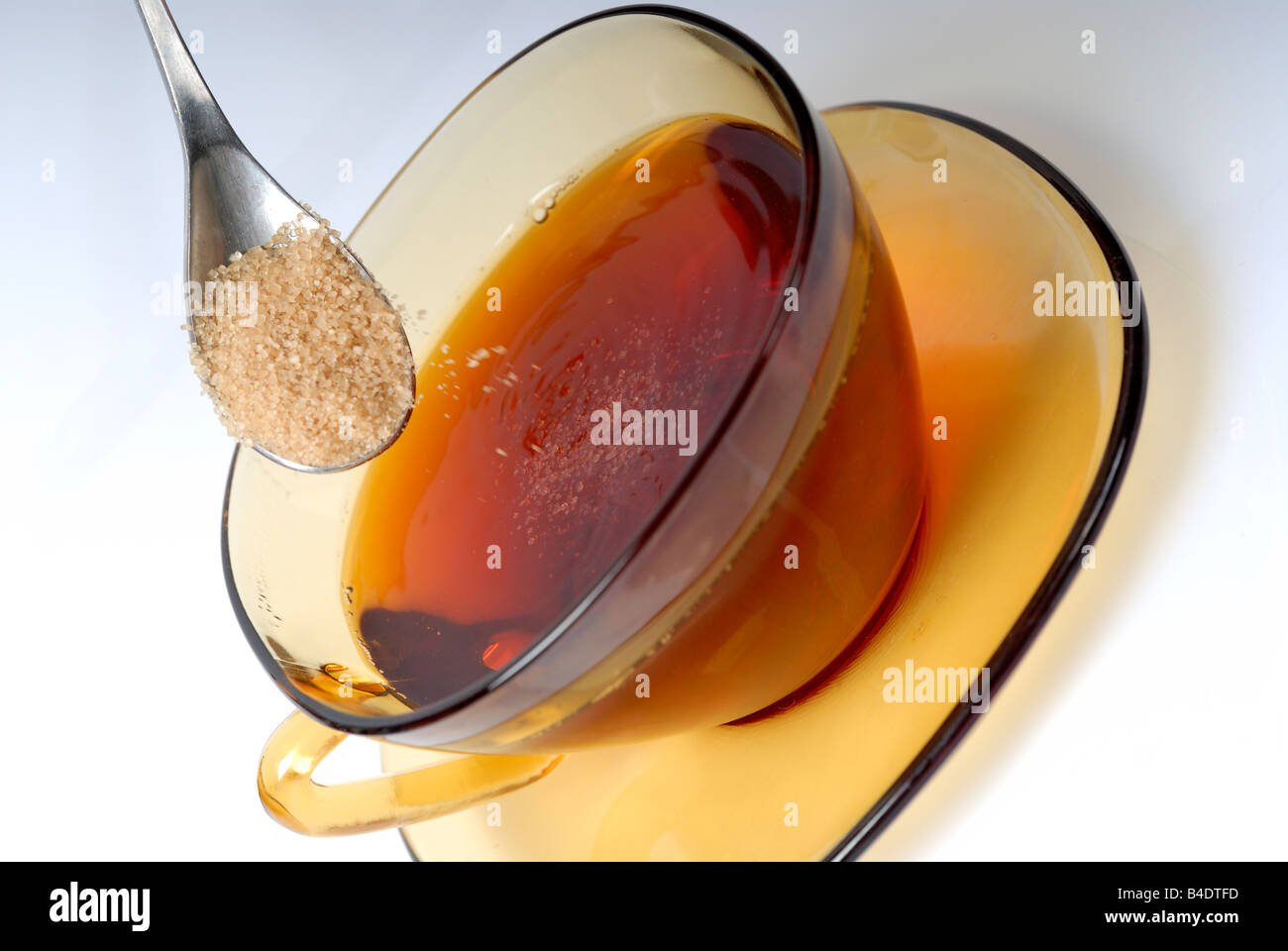 Stock photo of sugar being stirred into a glass of tea Stock Photo - Alamy