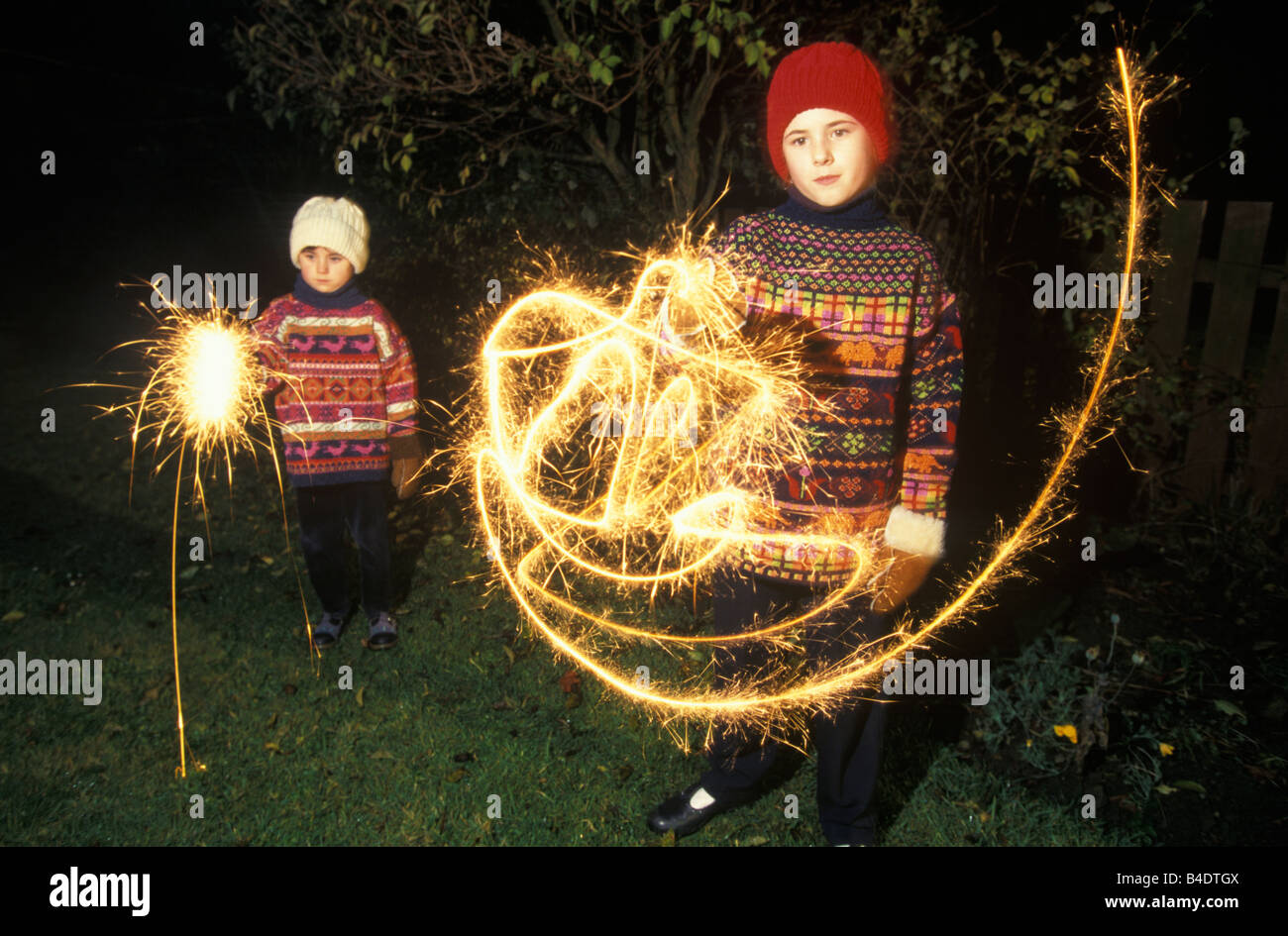 2 girls playing with sparklers on bonfire night Stock Photo - Alamy