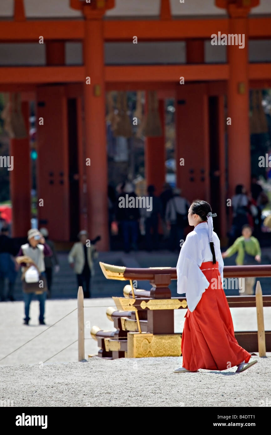 Girl in traditional Shinto shrine maiden dress, or miko hakama, walks ...