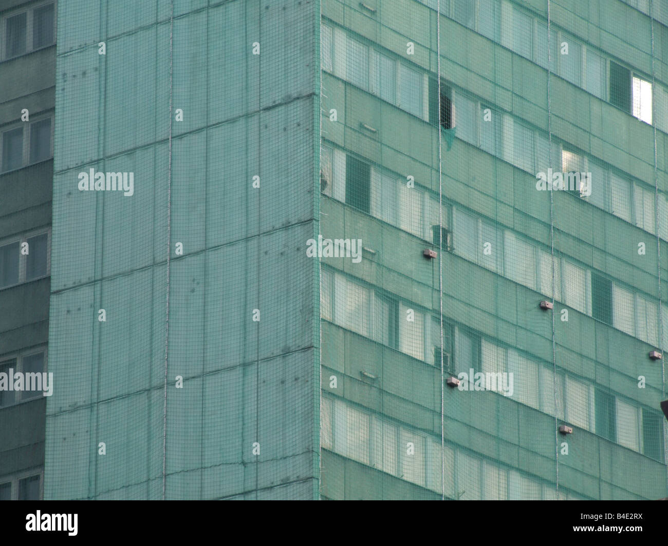 high rise building with green protective mesh net Stock Photo - Alamy