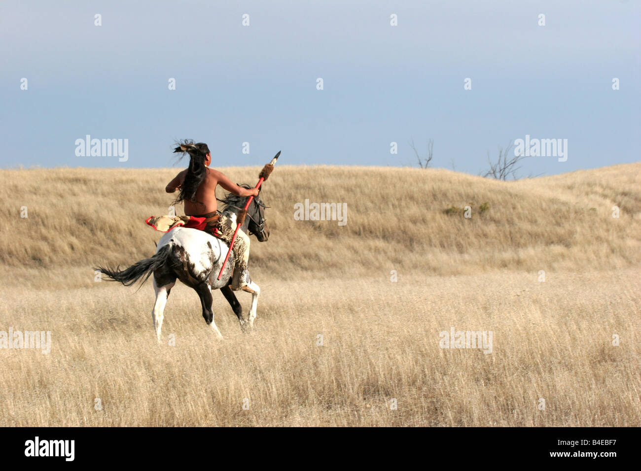 A Native American Indian with a spear riding horseback in South Dakota ...