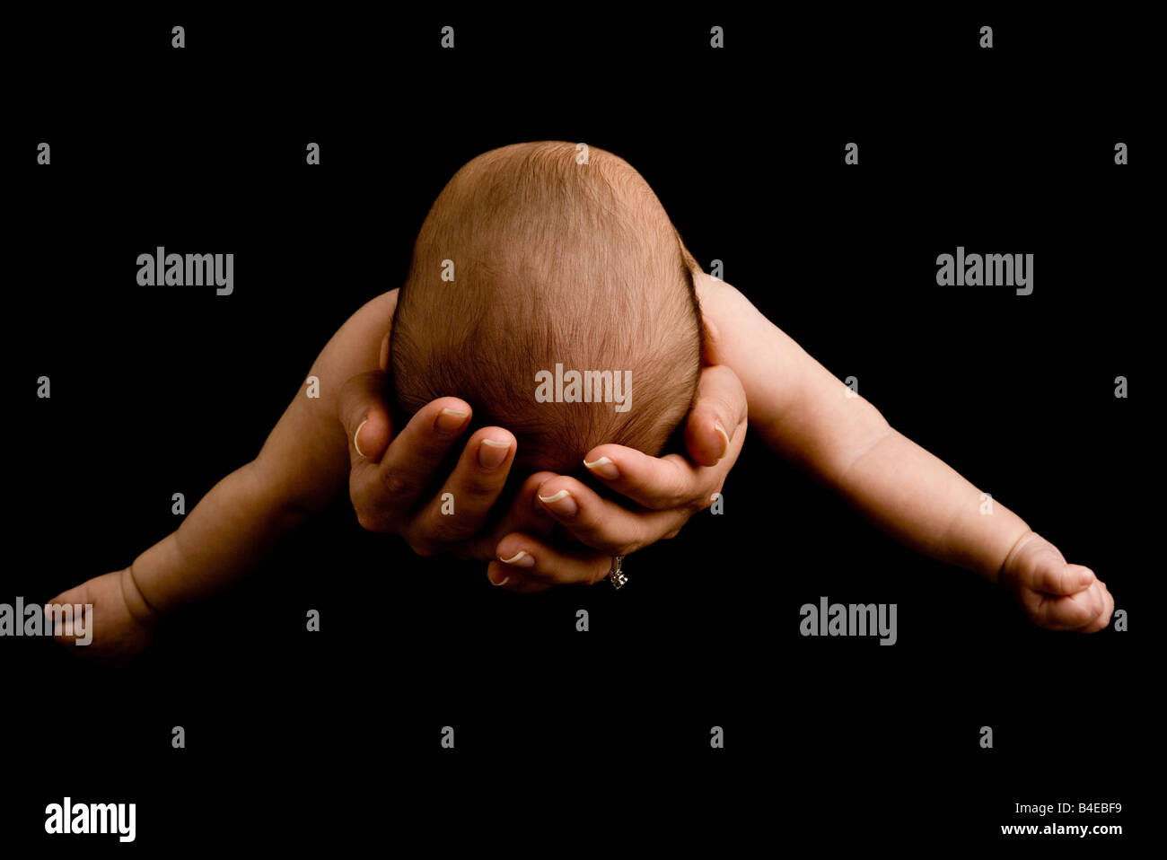 View of top of baby's head with arms wide open as she is outstretched ...