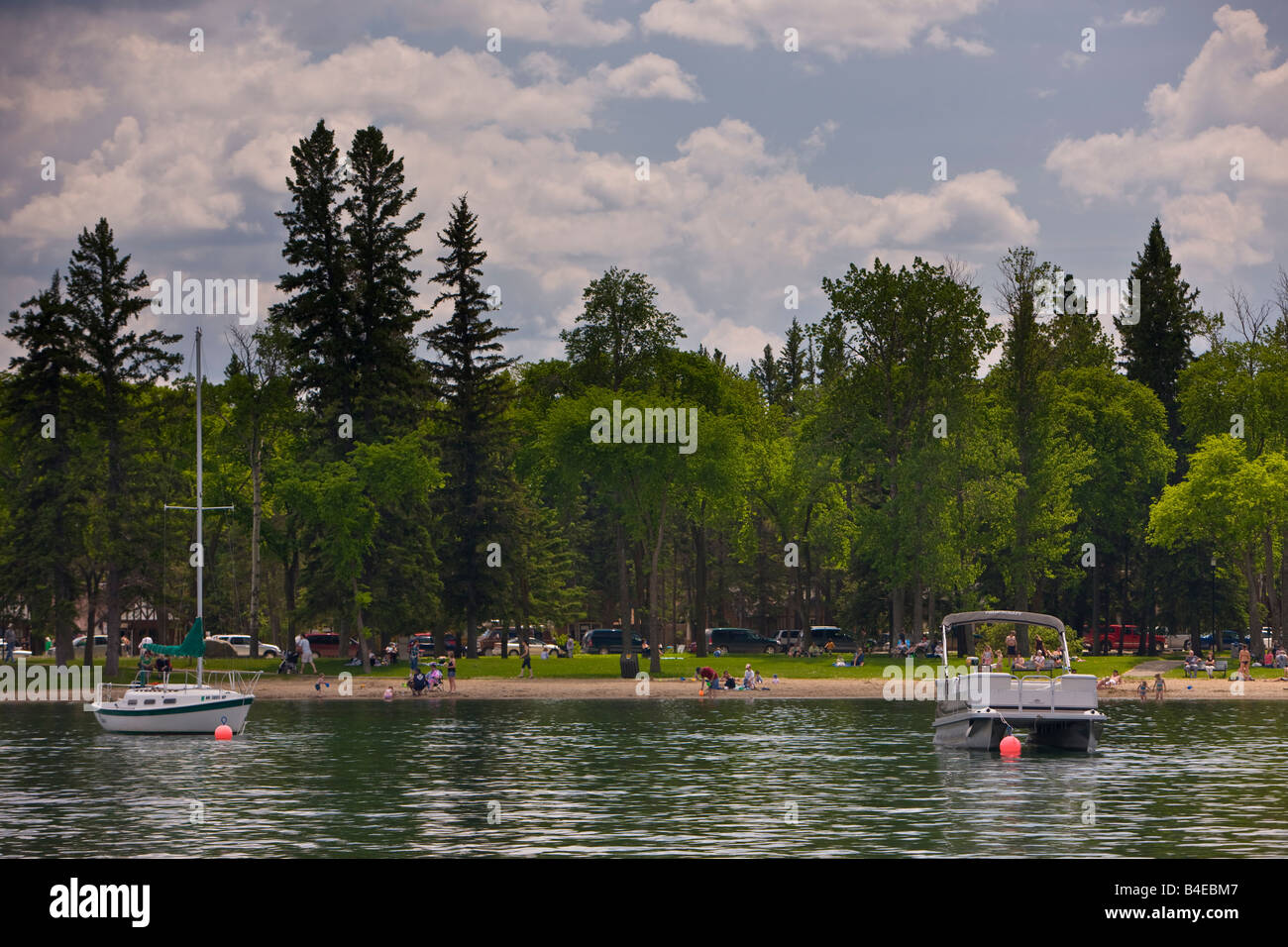 Holidaymakers relaxing on the sandy beach of Clear Lake in Wasagaming ...