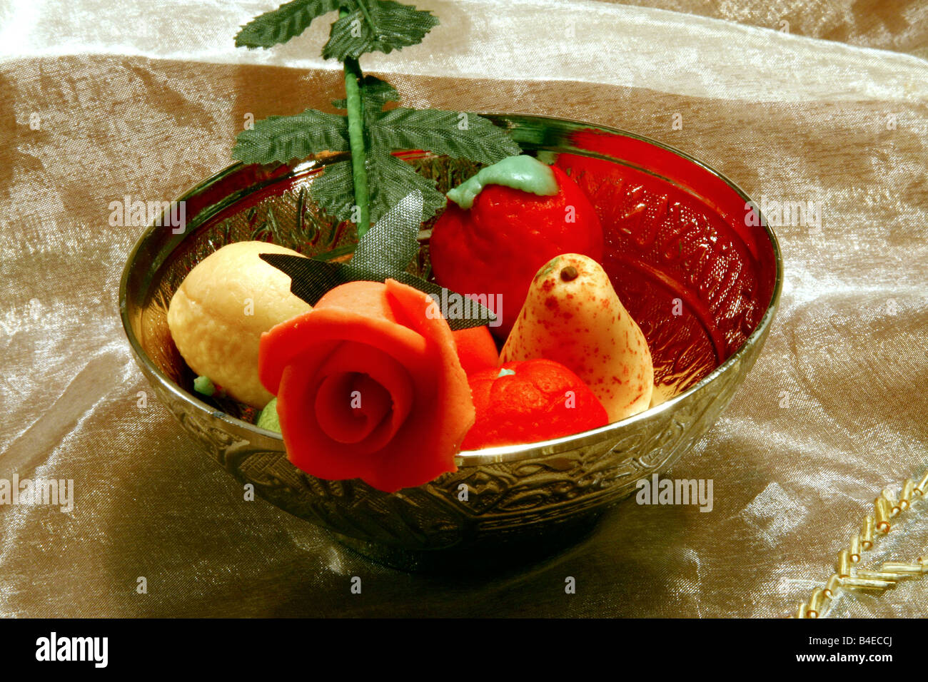 Fruit shaped marzipans with a rose shaped marzipan in a silver pot ...