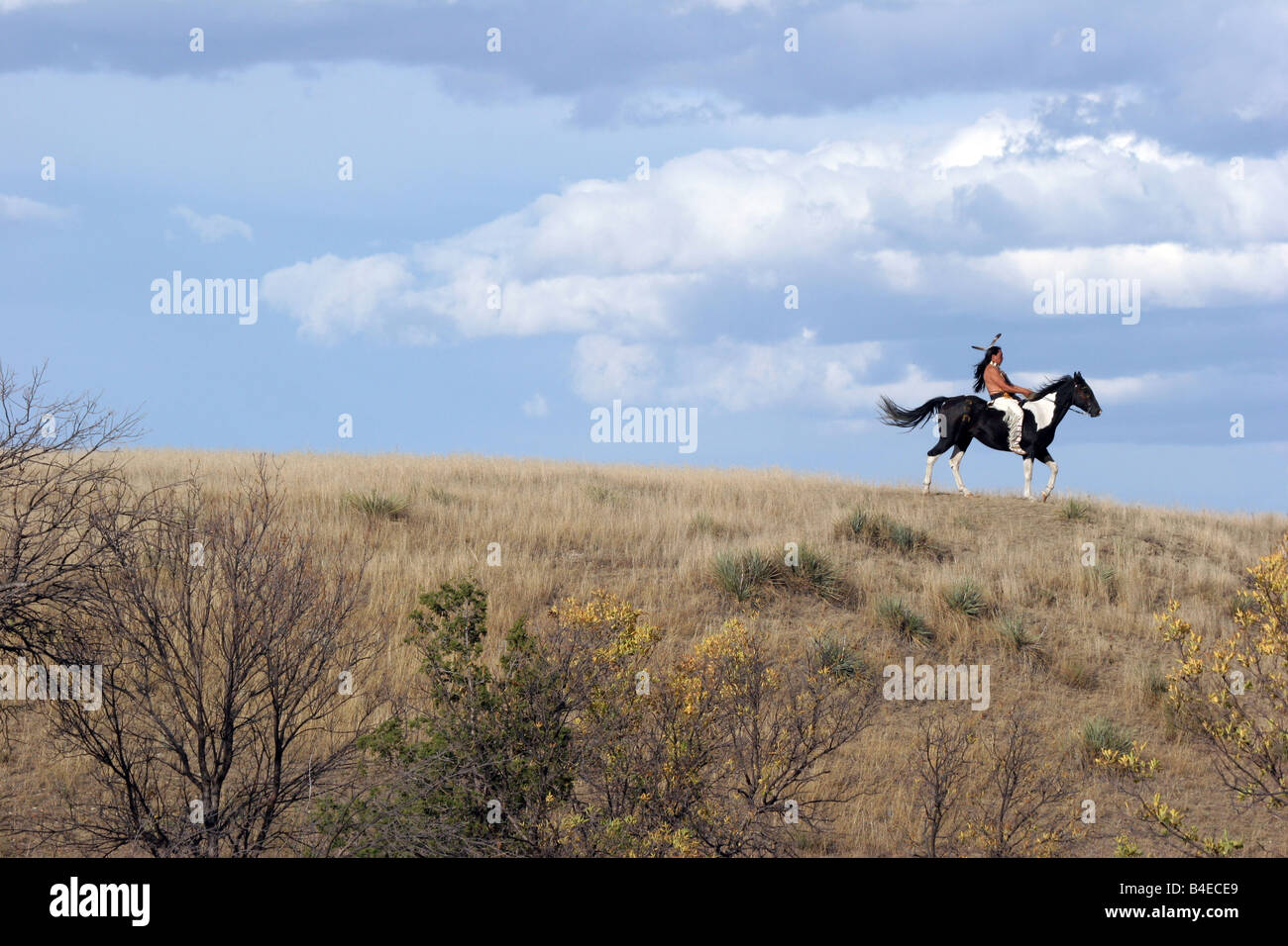A Native American Lakota Sioux Indian riding horseback on the prairie ...