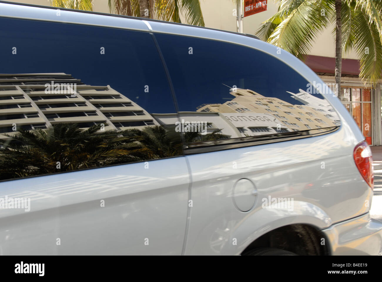 Luxury apartment buildings reflected in the side window of a minivan ...