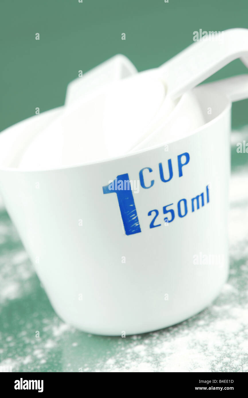 Measuring cups isolated against a green background Stock Photo - Alamy