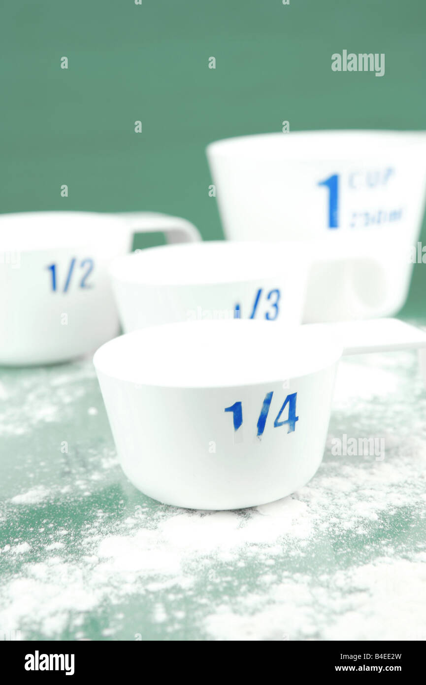 Measuring cups isolated against a green background Stock Photo - Alamy