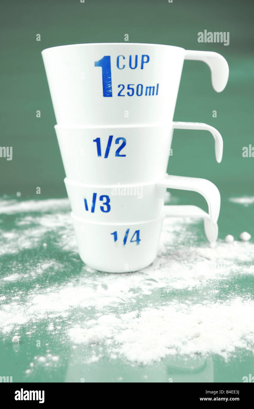 Measuring cups isolated against a green background Stock Photo - Alamy