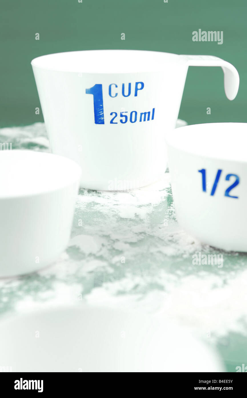 Measuring cups isolated against a green background Stock Photo - Alamy
