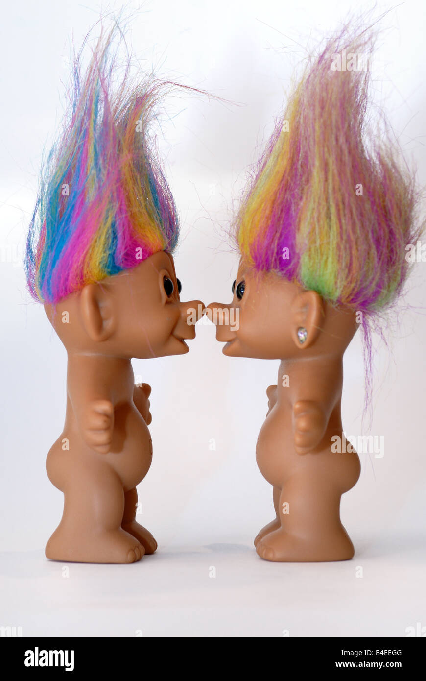 Two troll dolls with brightly colored hand stand face to face rubbing ...