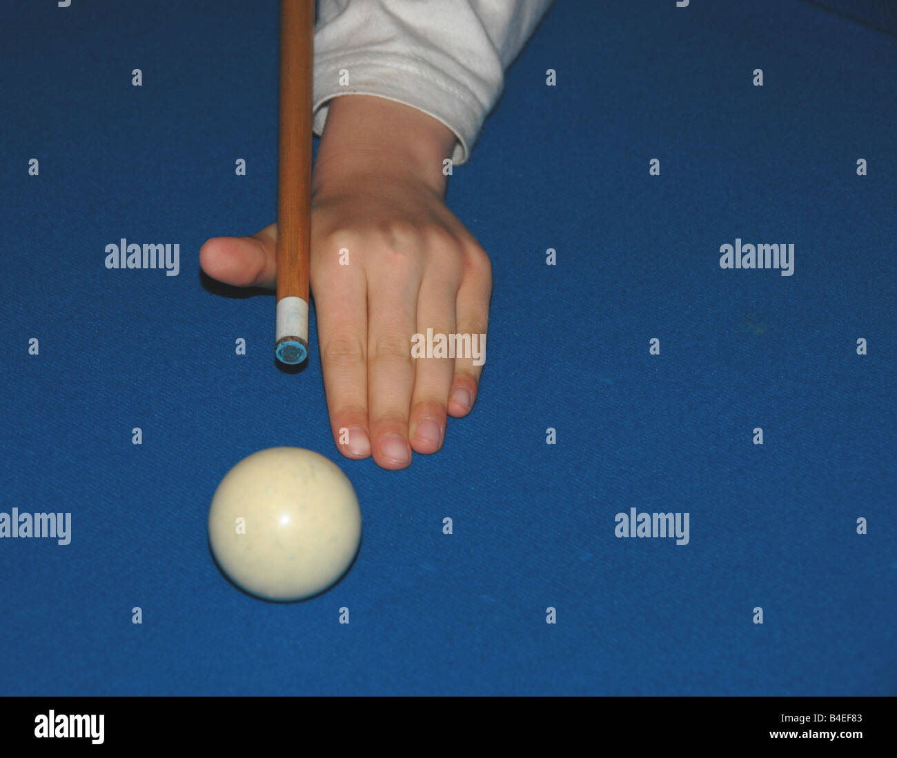 A close up of a young boy ready to strike the cue ball with the pool ...