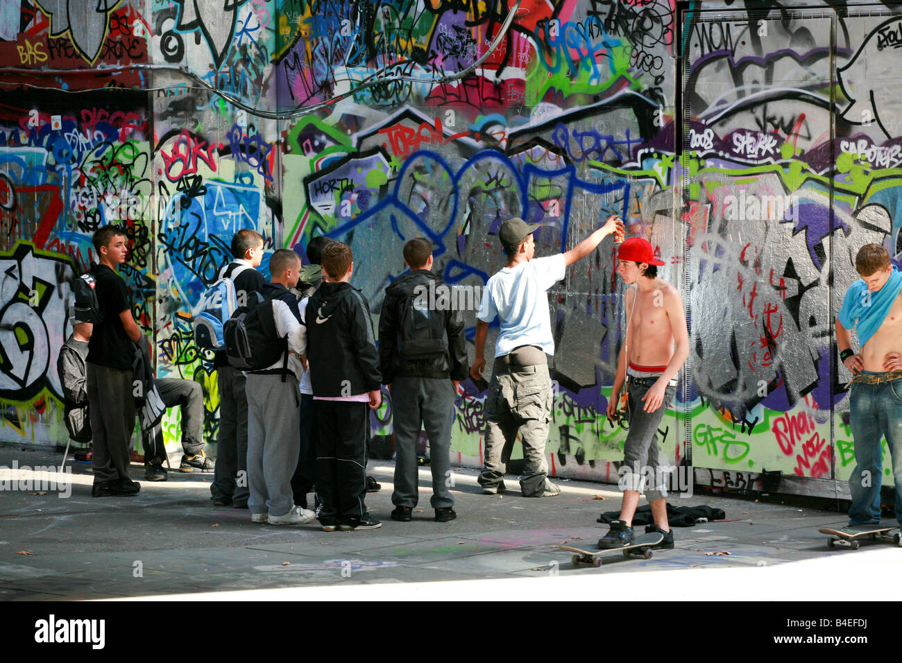 Group of young boys men teenagers hoodies delinquents skaters watch a ...