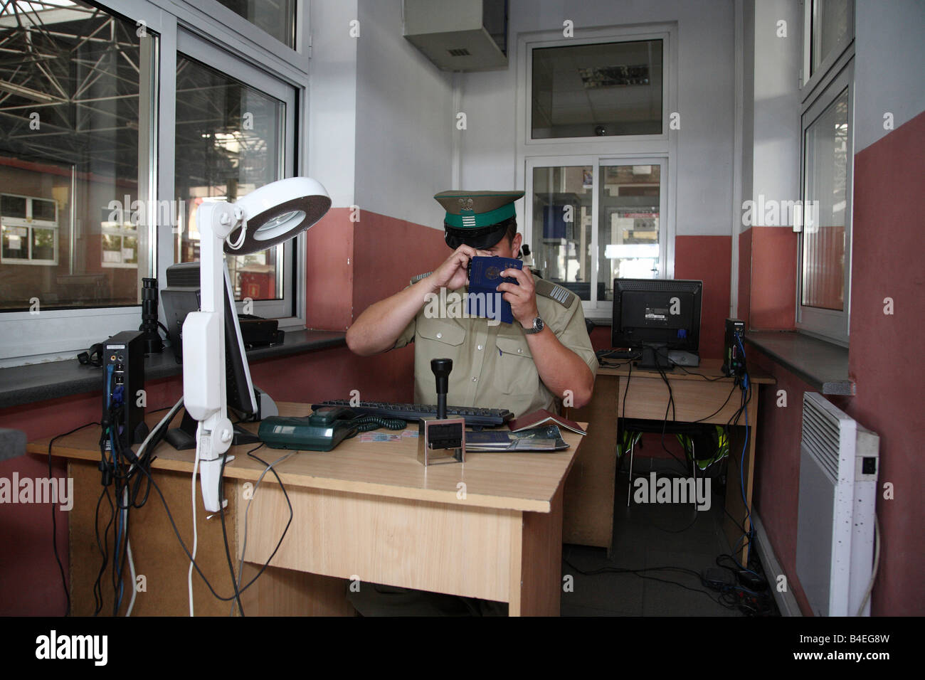 Polish border guard checking the authenticity of a passport, Terespol ...