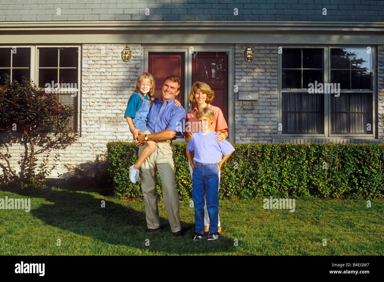 Family standing in front of house hi-res stock photography and images ...