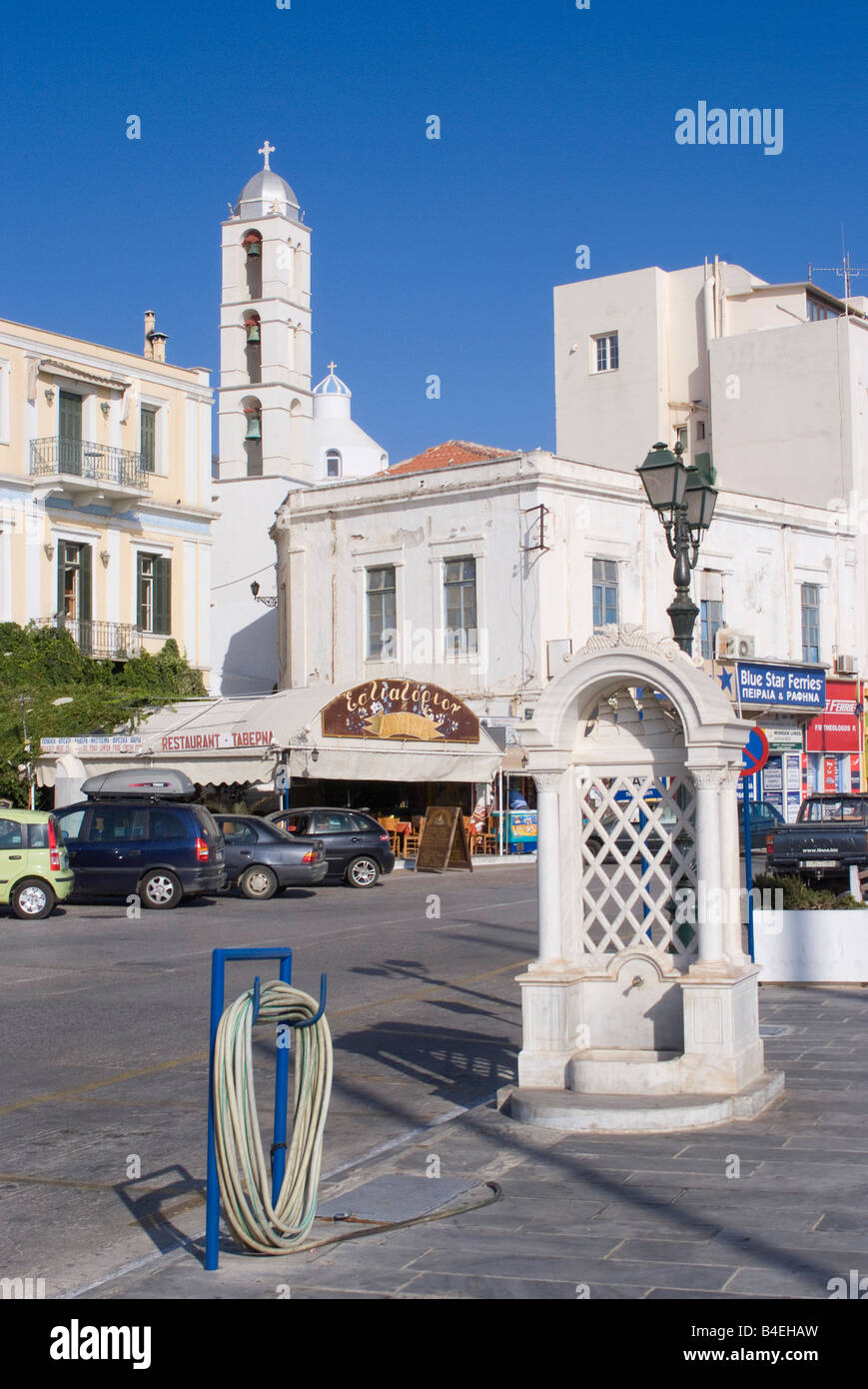 Drinking Fountain on Waterfront with Restaurant and Church in Tinos ...