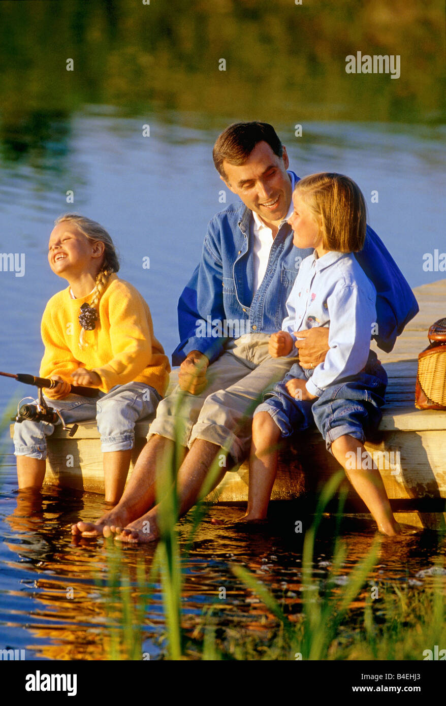 father and children fishing from dock Stock Photo - Alamy