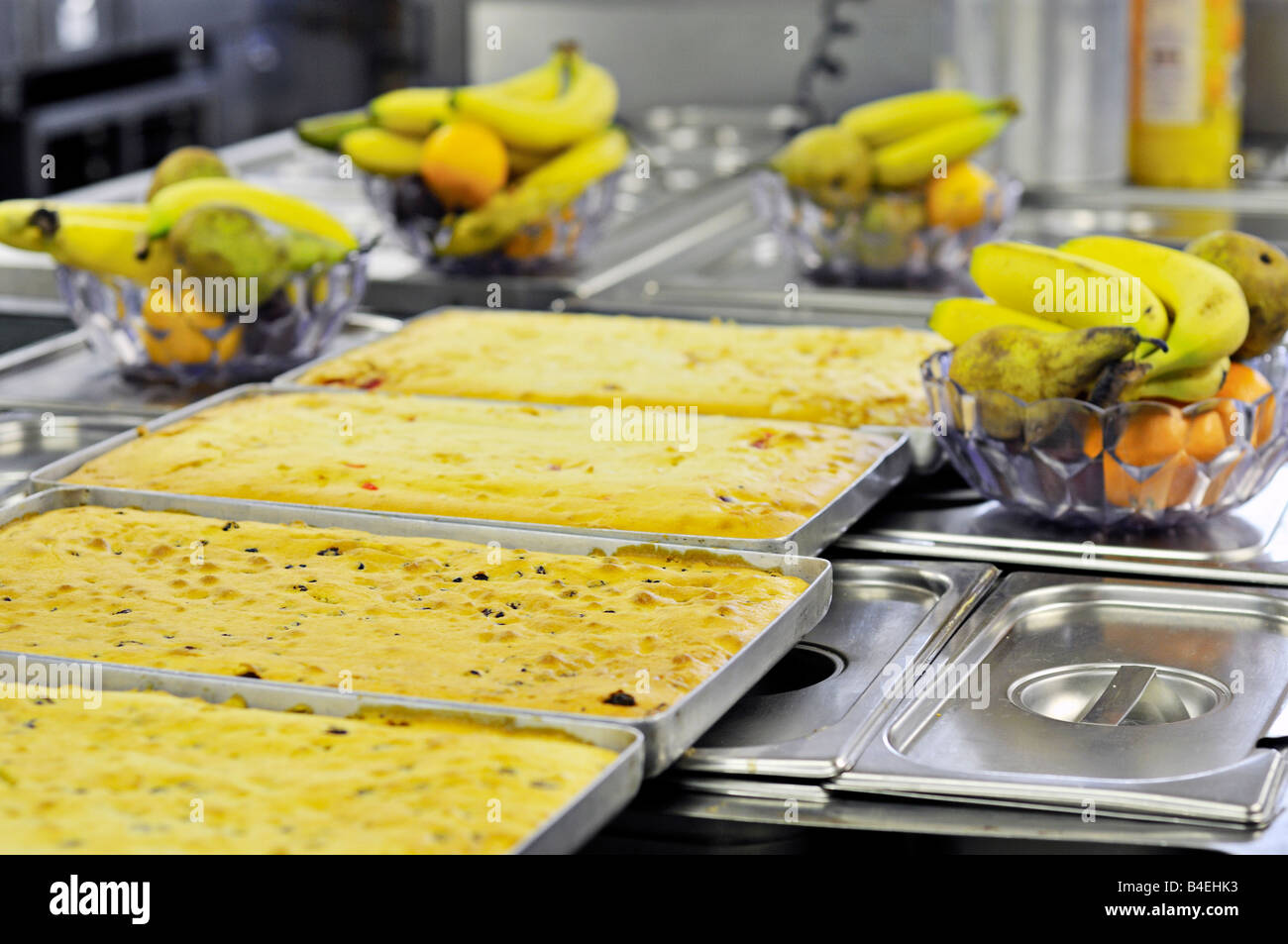 Professional kitchen showing the preparation of cake tins and fruit ...