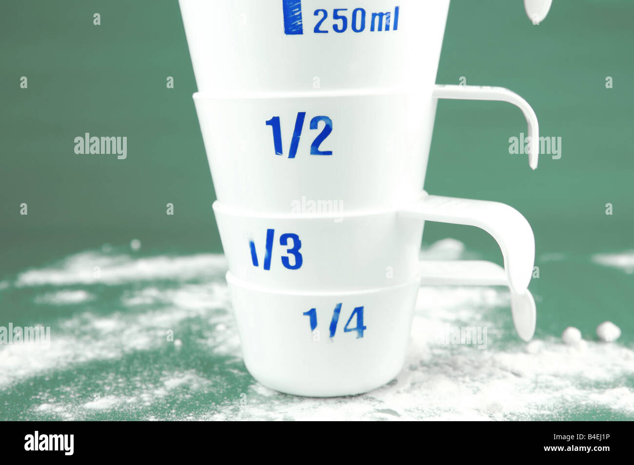 Measuring cups isolated against a green background Stock Photo - Alamy