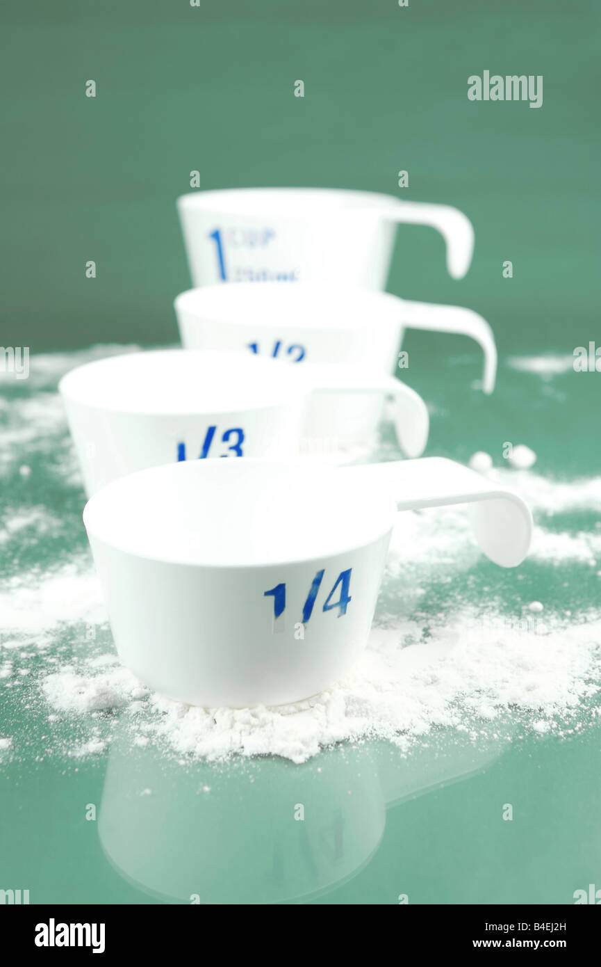 Measuring cups isolated against a green background Stock Photo - Alamy