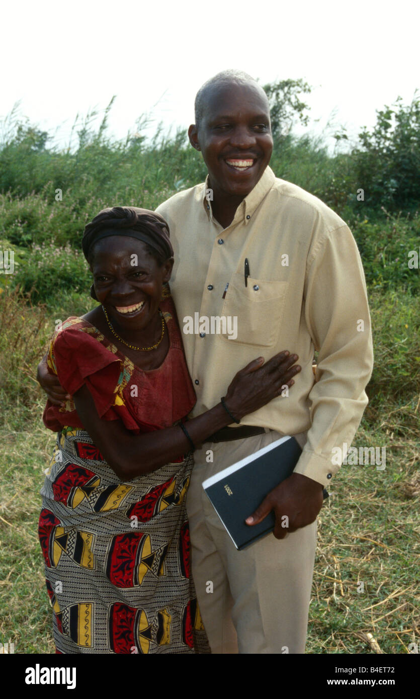A farm worker hugs an officer at an agriculture project in Uganda Stock ...