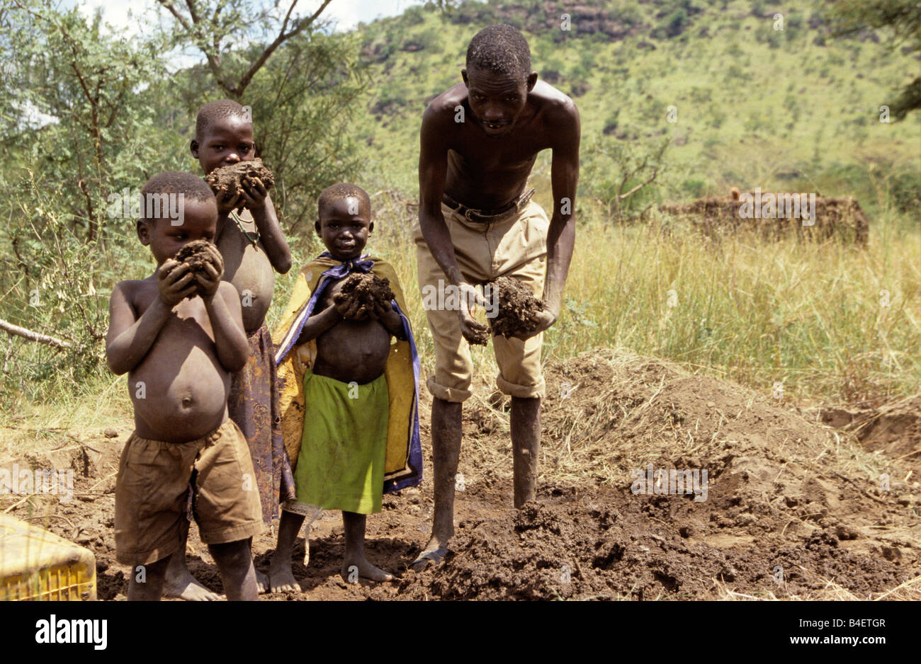 Brick maker and children holding clay and straw clumps used to make ...
