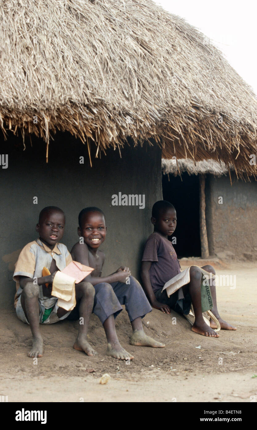 Young boys studying outside hut in village. Uganda Stock Photo - Alamy