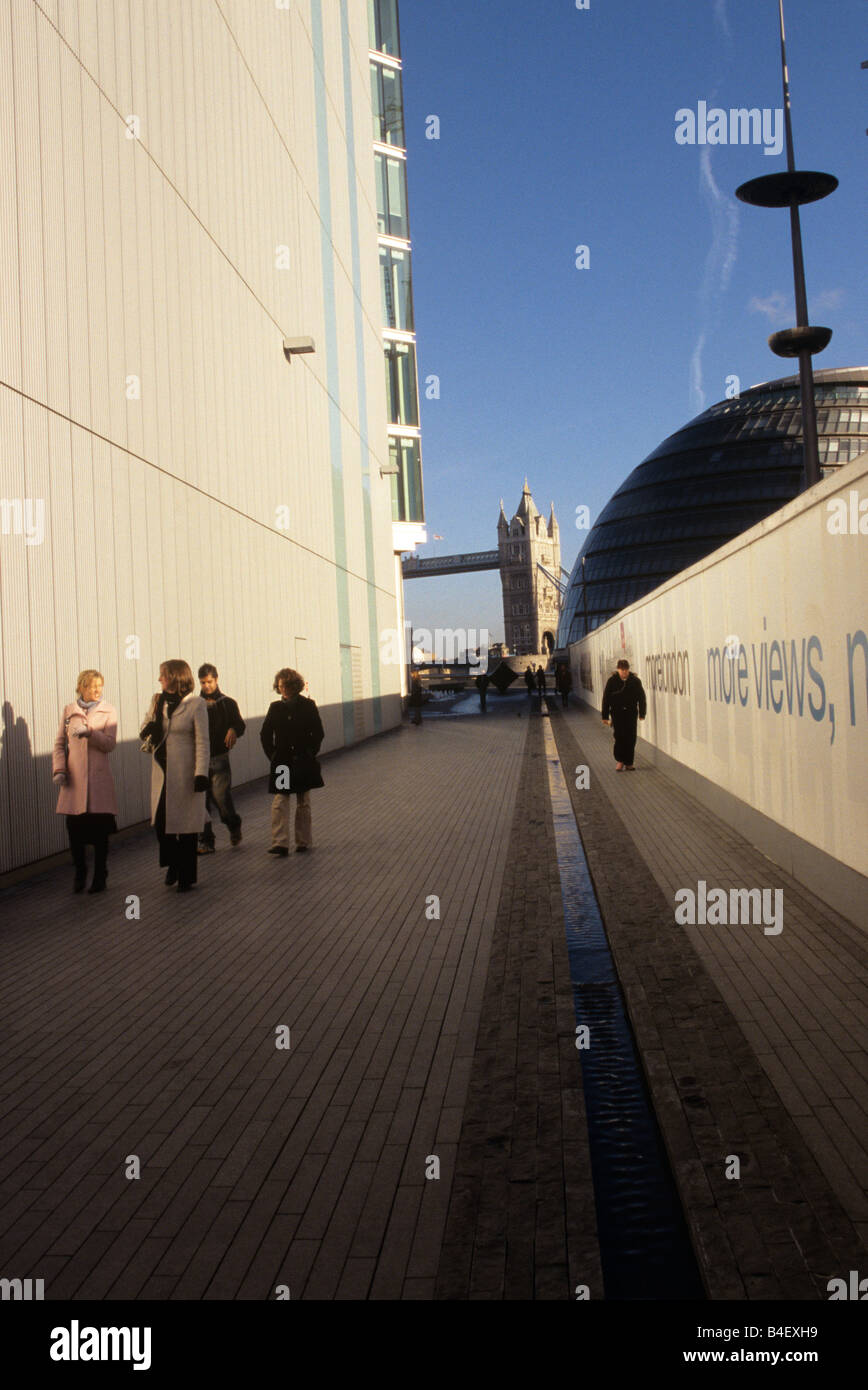 A walkway in London with the Tower Bridge and the City Hall visible in ...