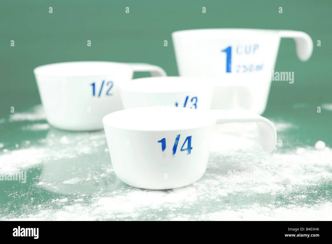 Measuring cups isolated against a green background Stock Photo - Alamy