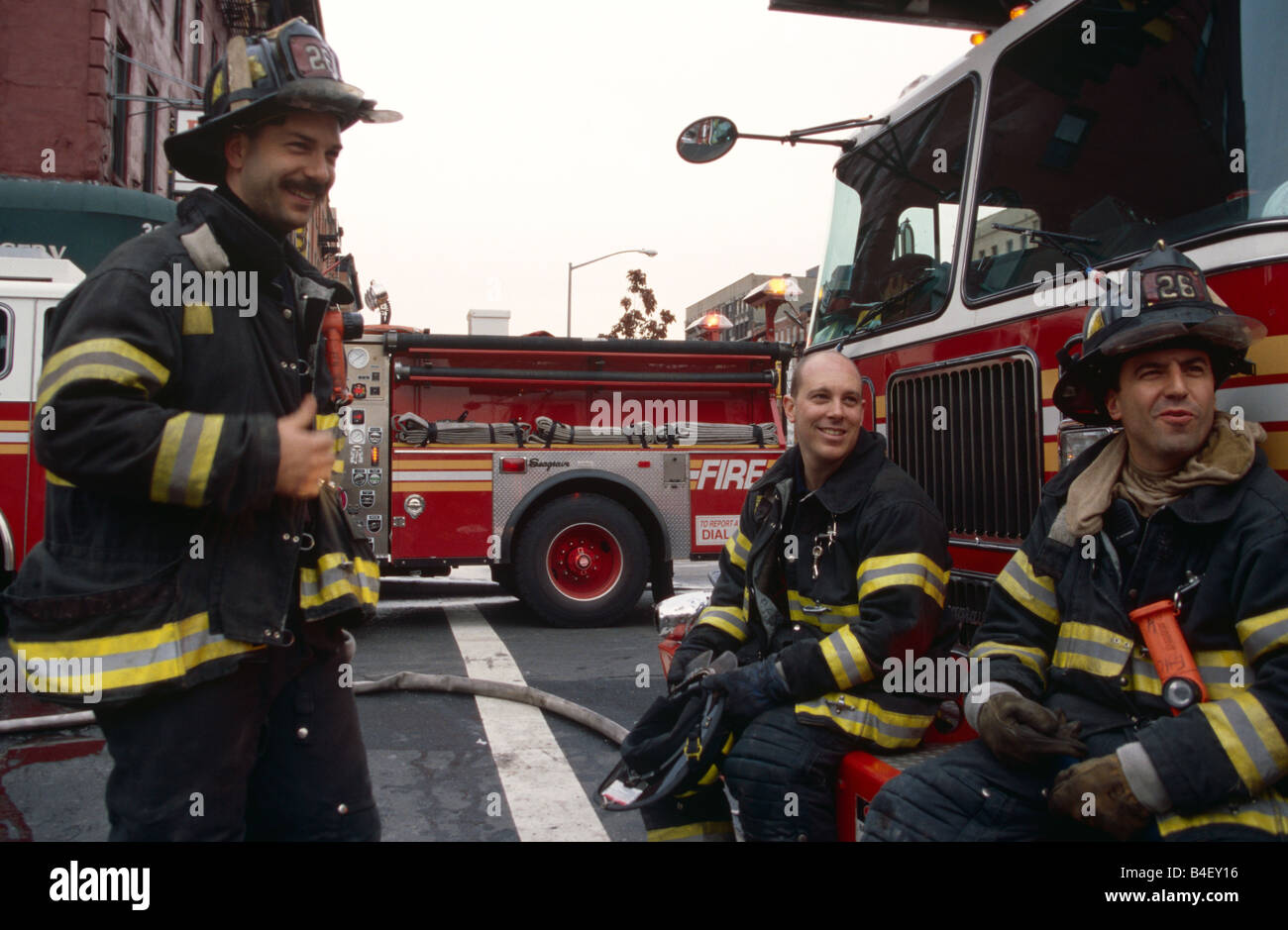 FDNY firefighters sitting on edge of fire engine, New York City, USA ...