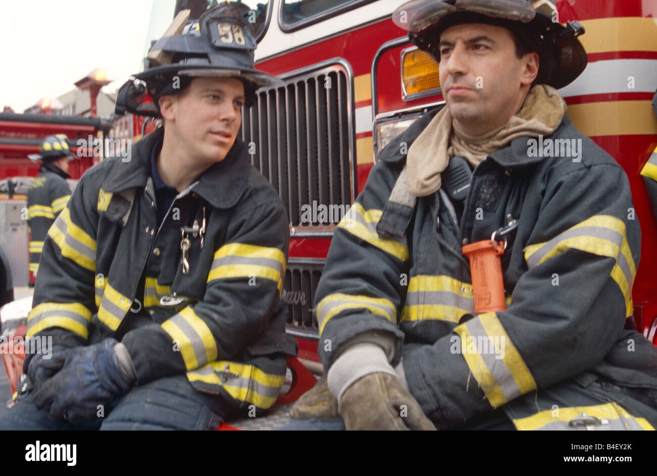 FDNY firefighters talking on edge of fire engine, New York City, USA ...