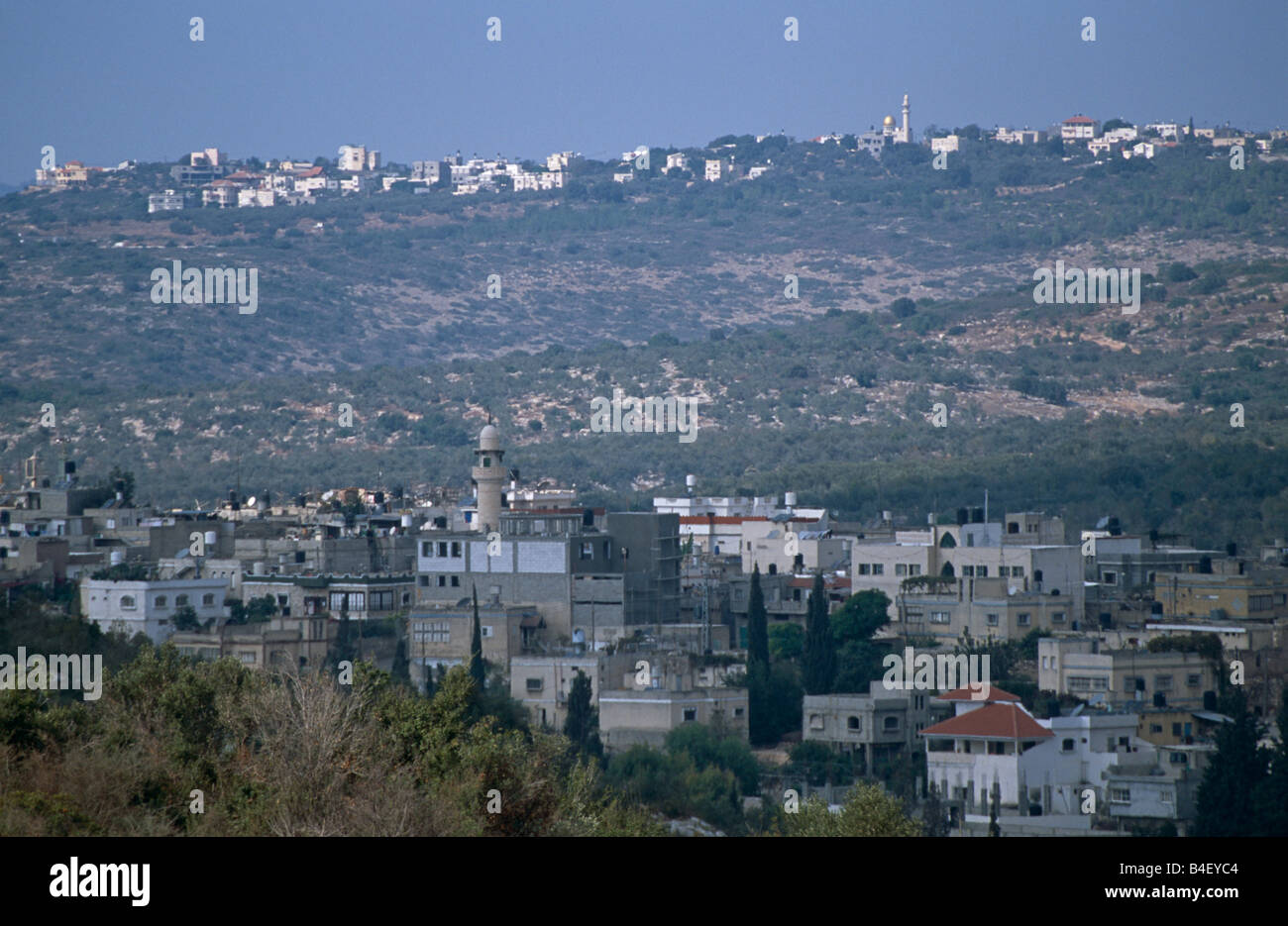 A village in Palestine with an Israeli settlement in the background ...