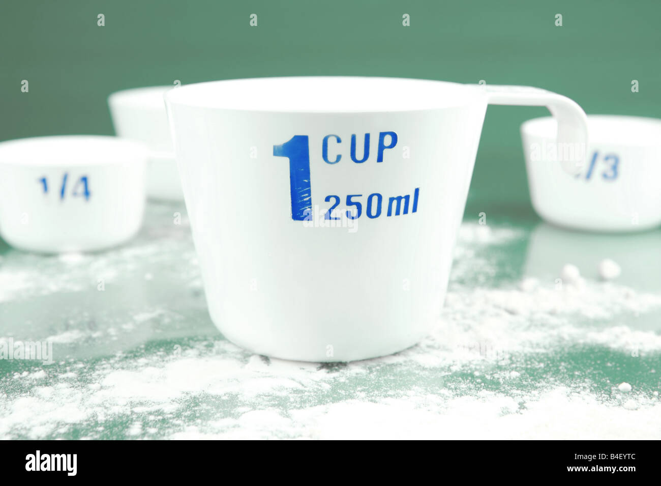 Measuring cups isolated against a green background Stock Photo - Alamy