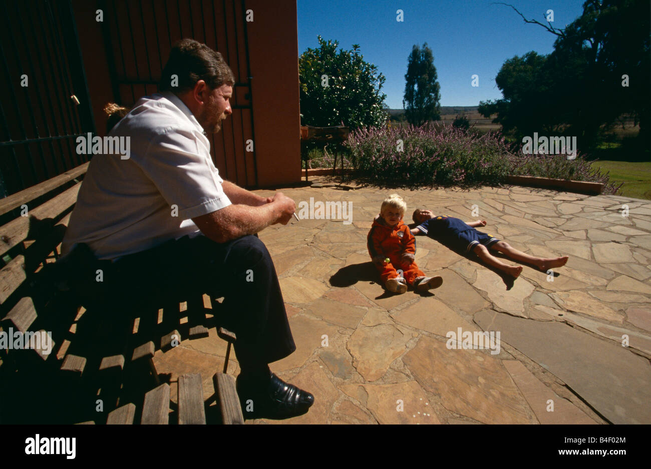 Father watching children playing in park, South Africa Stock Photo - Alamy