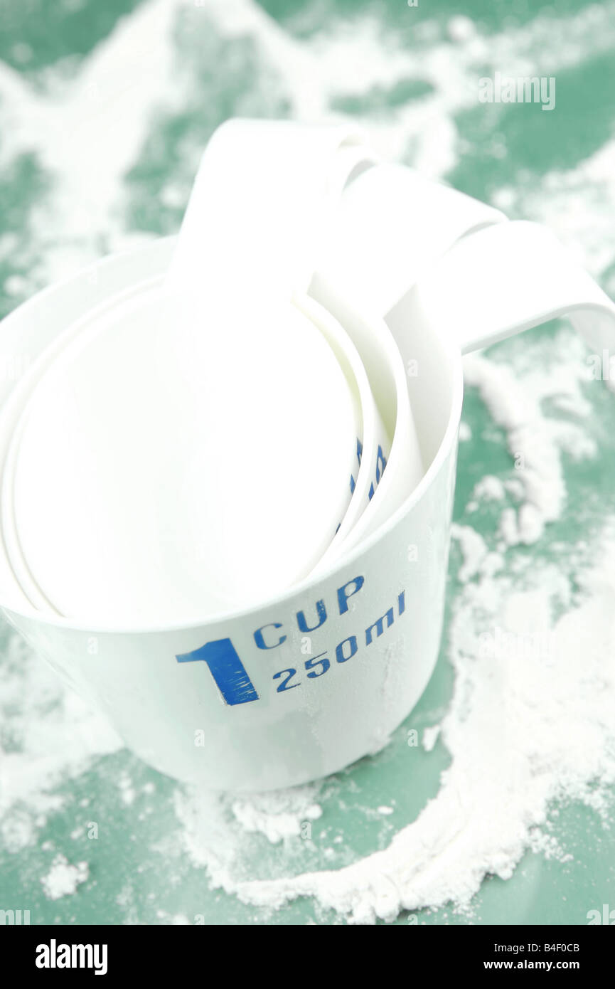 Measuring cups isolated against a green background Stock Photo - Alamy