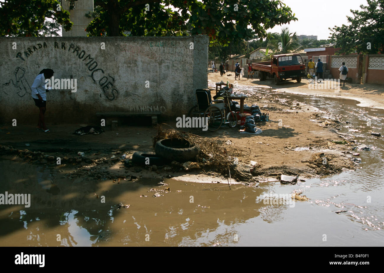 Woman walking with effort on flooded street, Angola Stock Photo - Alamy