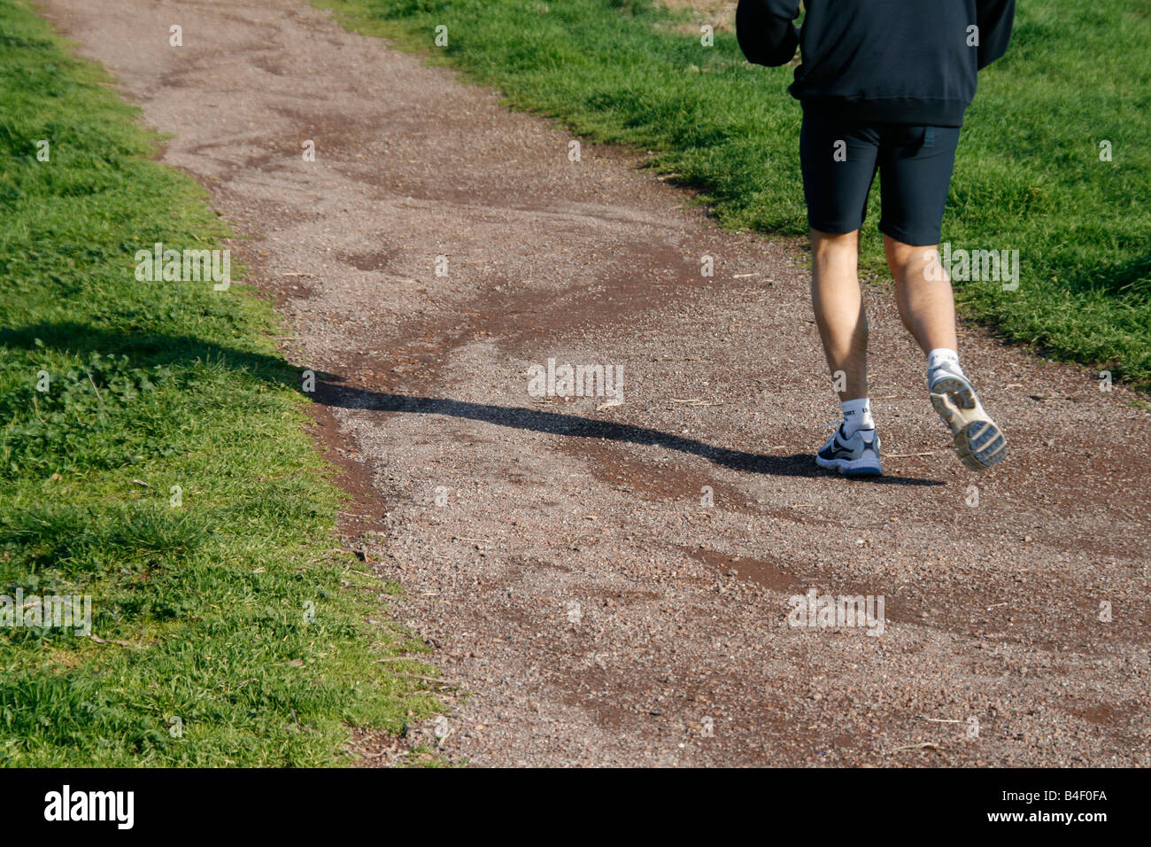 one single person jogging on path in park Stock Photo - Alamy